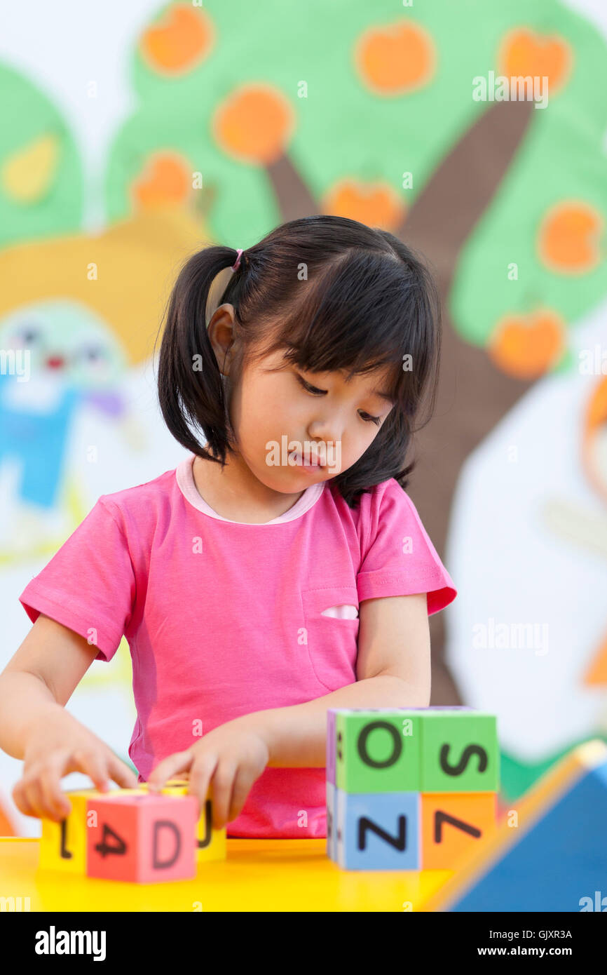 Little girl playing with blocks Stock Photo - Alamy