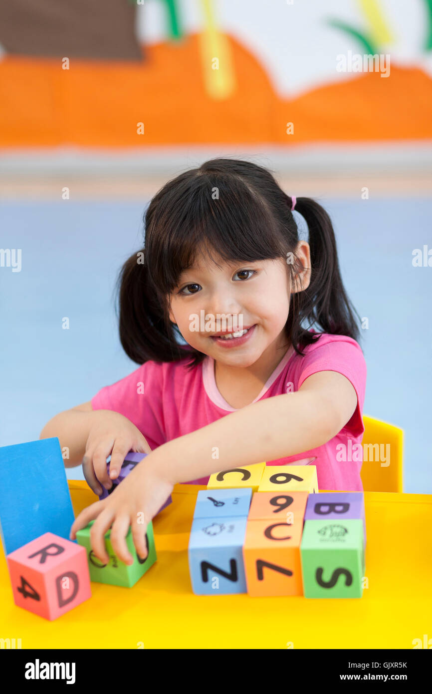 Little girl playing with blocks Stock Photo - Alamy