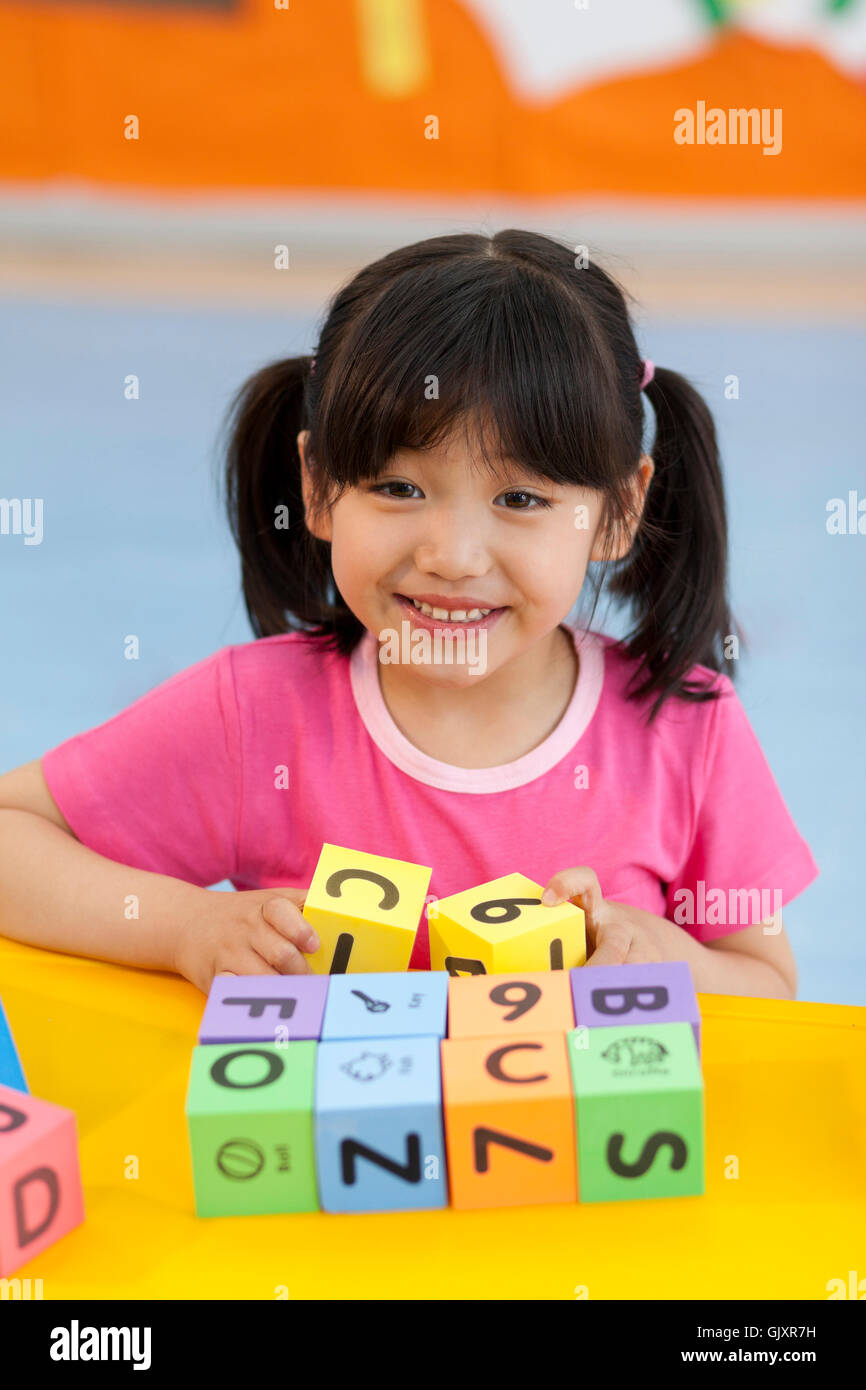 Little girl playing with blocks Stock Photo - Alamy