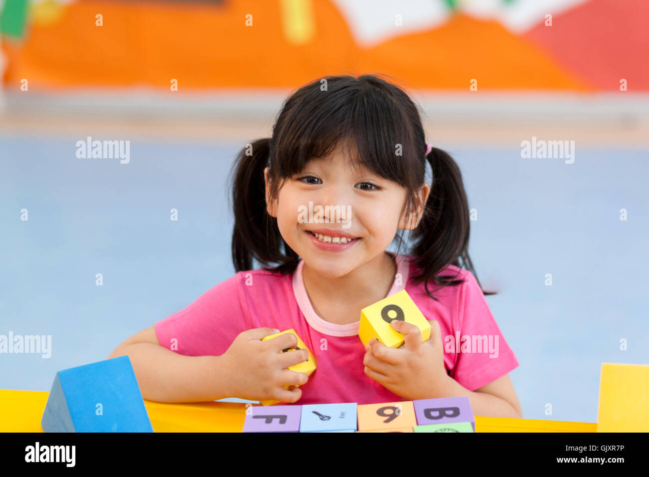 Little girl playing with blocks Stock Photo - Alamy