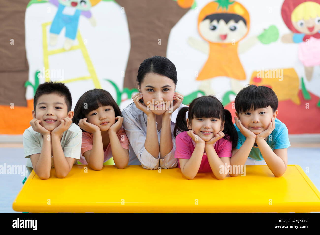 Female teachers and children learning together Stock Photo - Alamy