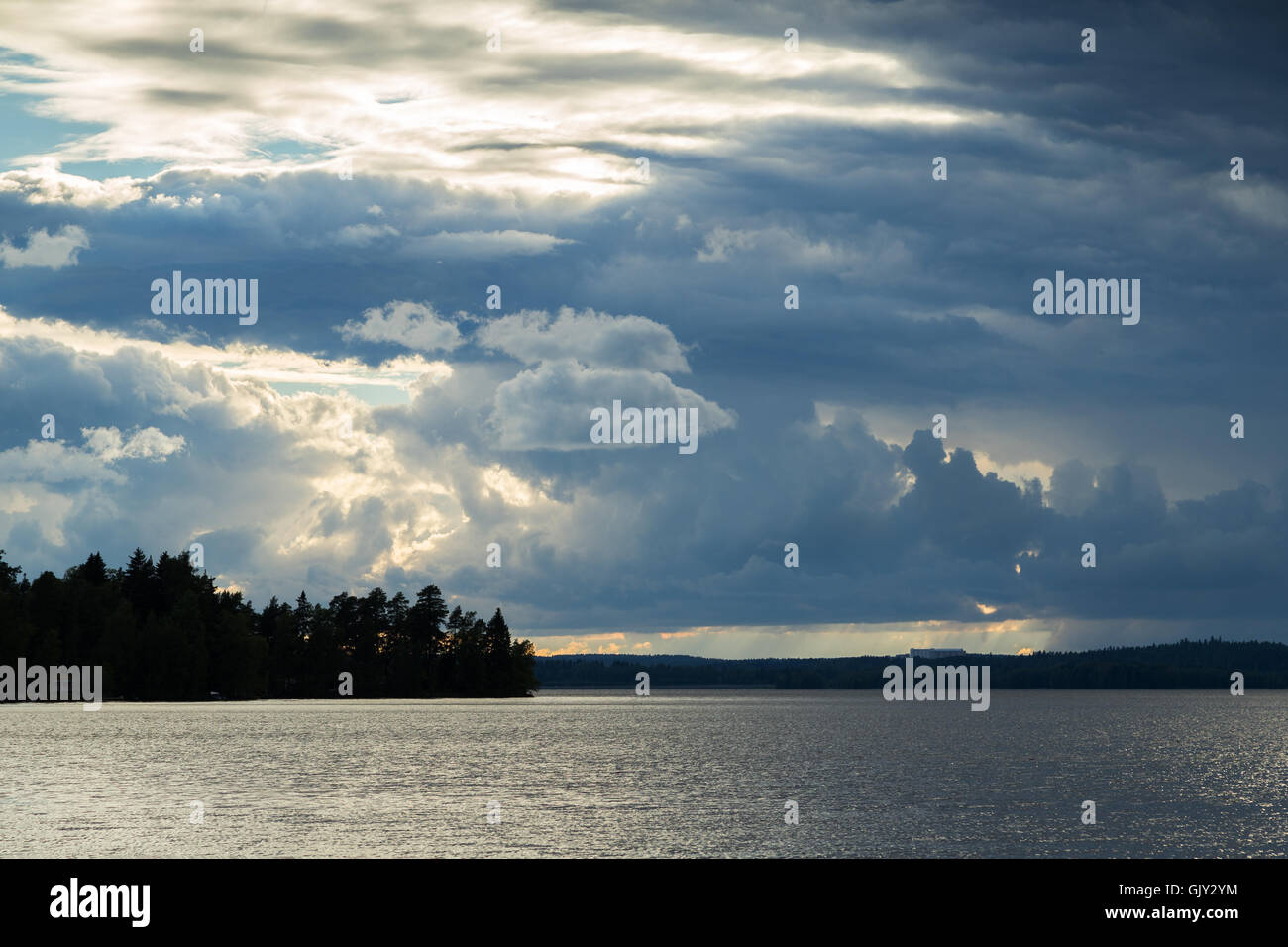 View of dark and dramatic clouds and a lake in Finland at early evening ...