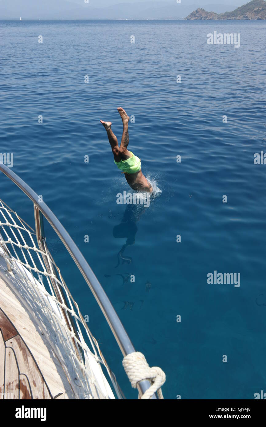 A man diving into the sea from the side of a boat Stock Photo - Alamy