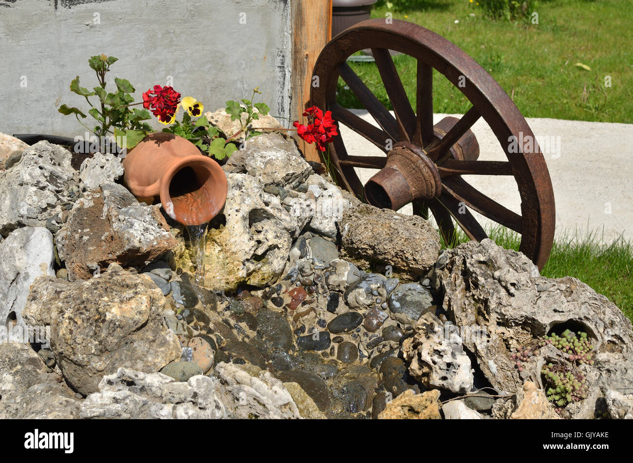 Water flowing from a ceramic jar in garden decoration of ethnic look ...