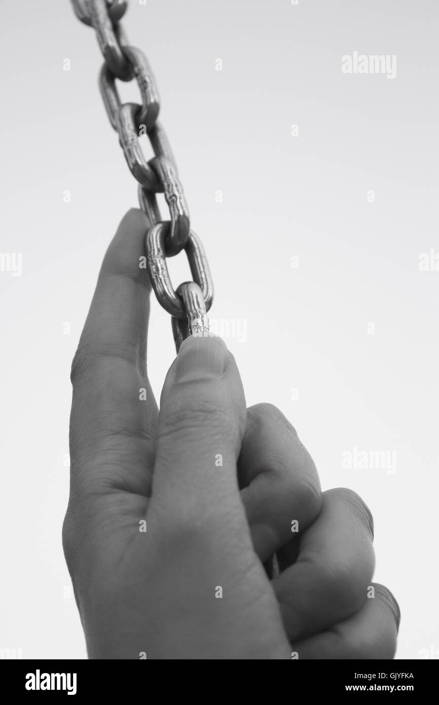 Woman hand clutching a silver chain Stock Photo - Alamy