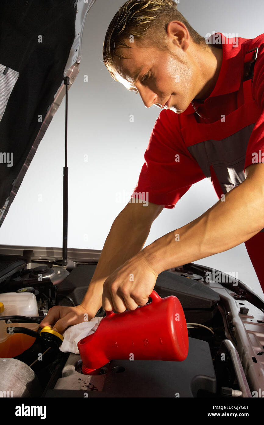 car mechanic refill the engine oil Stock Photo - Alamy