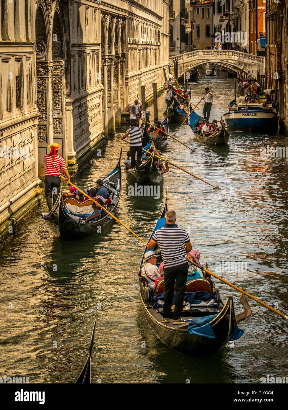 Busy canal in Venice with lots of gondolas carrying tourists, on ...