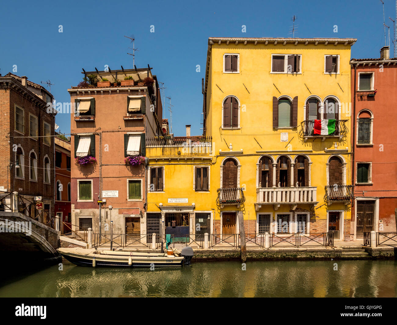 Traditional canal side buildings with yellow and brown rendered ...