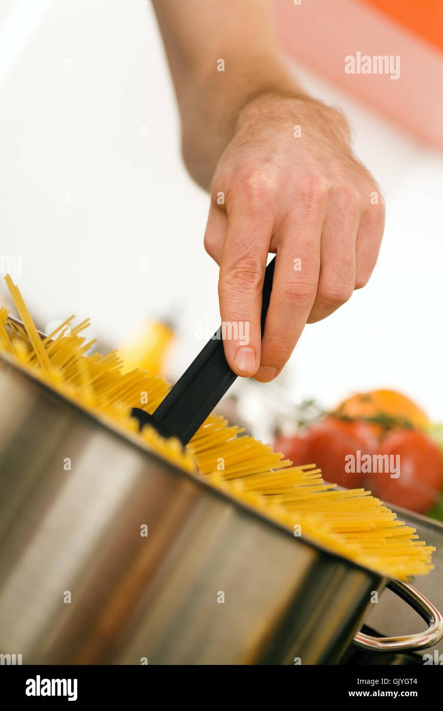 Pasta cooking hand pot water home hi-res stock photography and images ...