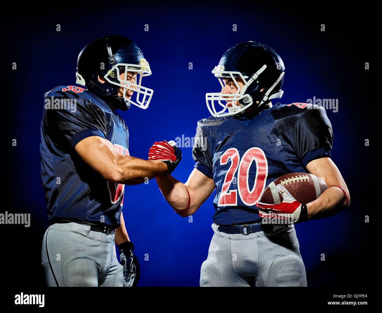two american football players men isolated on colorful black background ...