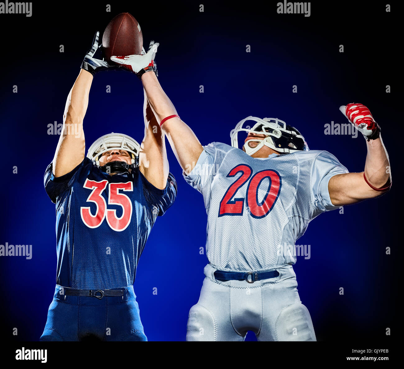 two american football players men isolated on colorful black background ...