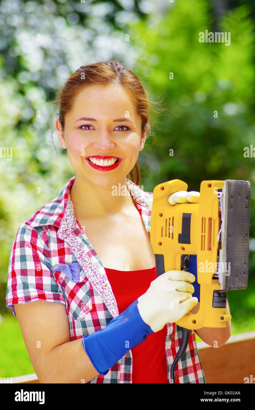 smiling women with colorfull clothes holding a eletric sander Stock ...