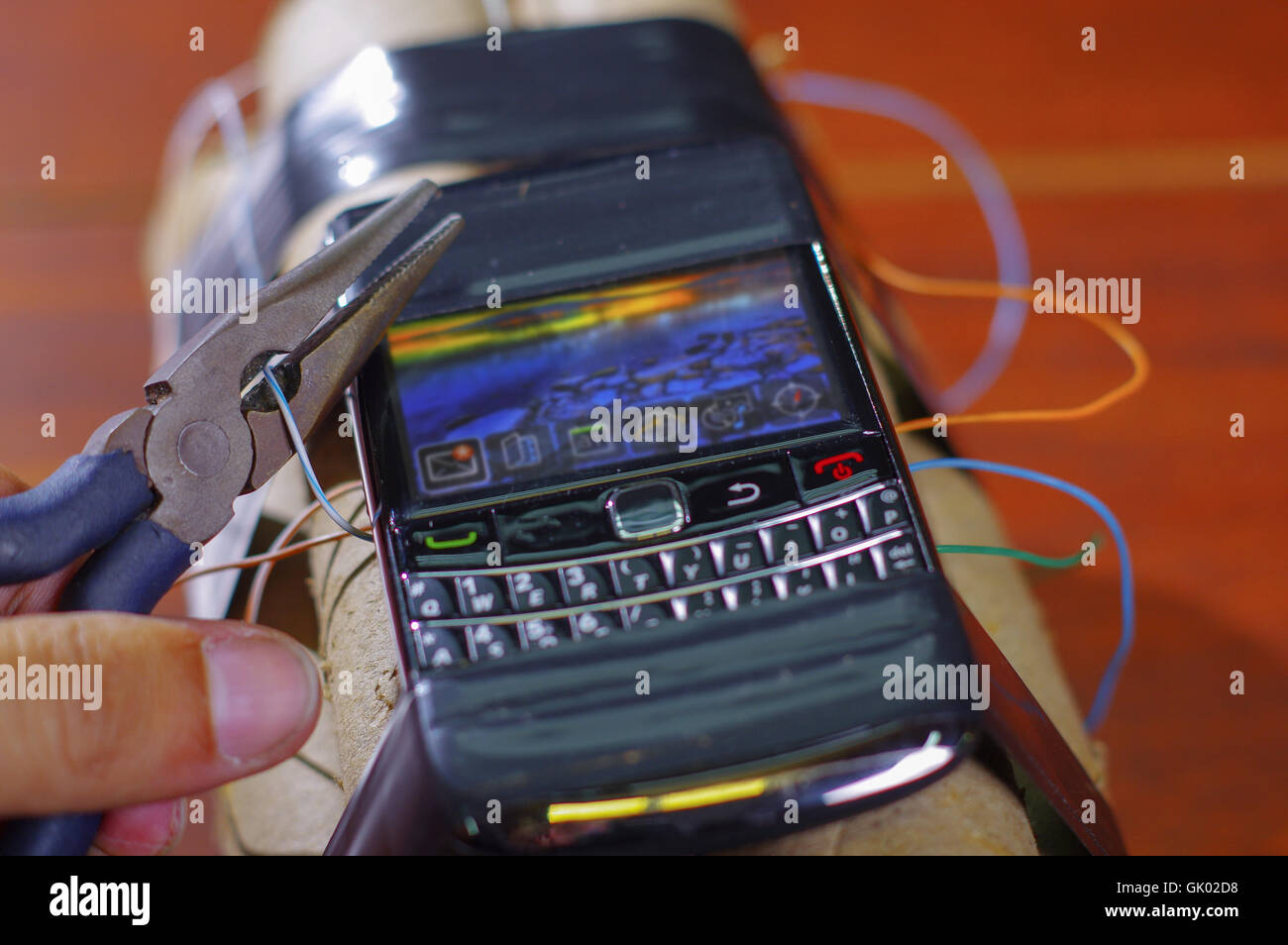 hand trying to cut the cable that connect the cellphone with the ...