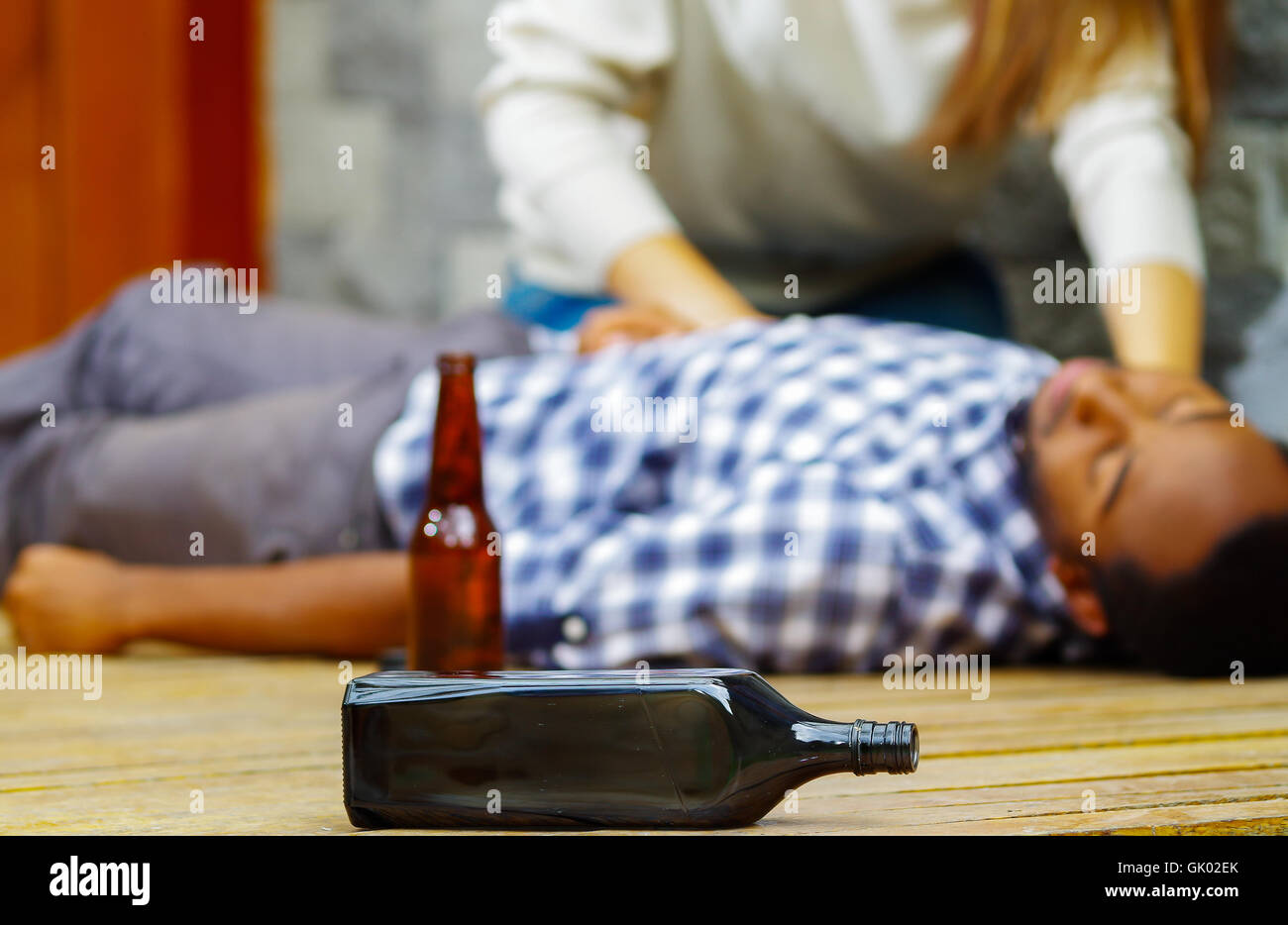 Man wearing casual clothes lying drunk passed out on wooden surface ...