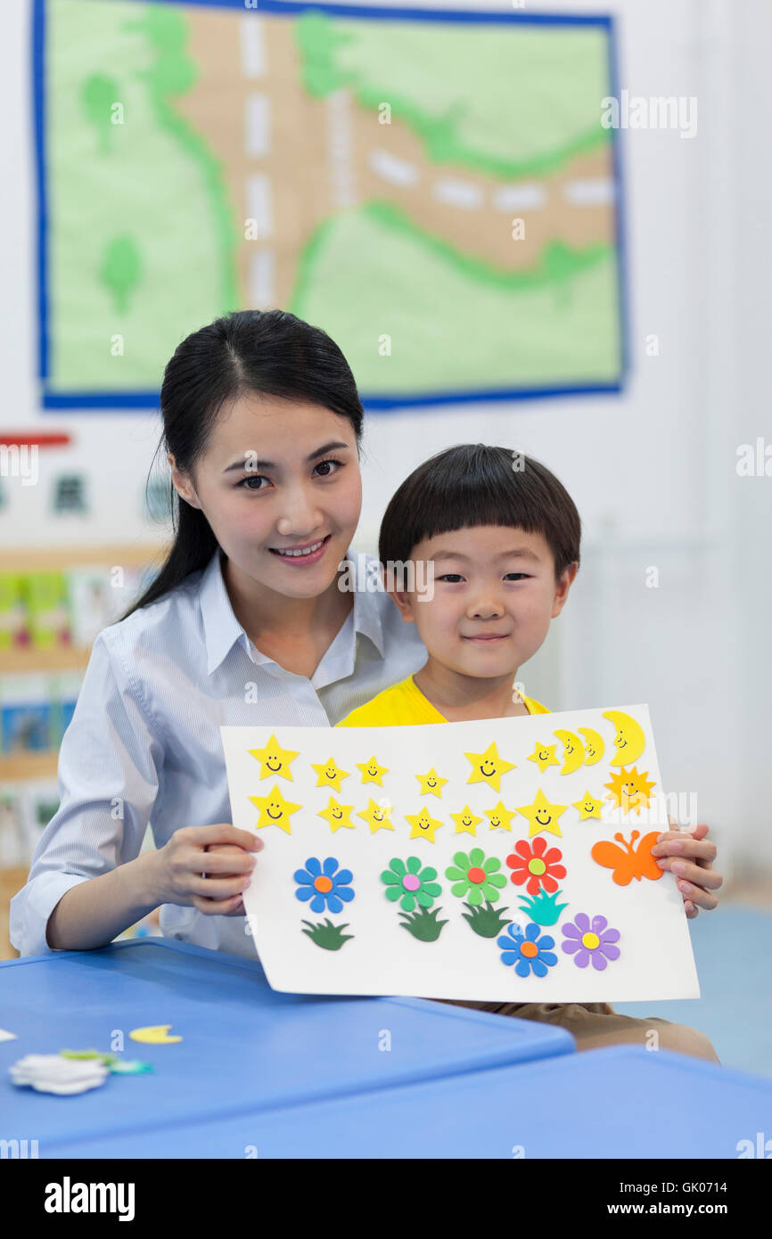 Female teachers and children drawing together Stock Photo - Alamy