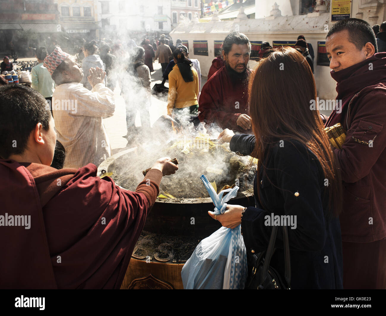 Pilgrims at the Boudhanath Stupa burning incense and praying Stock ...