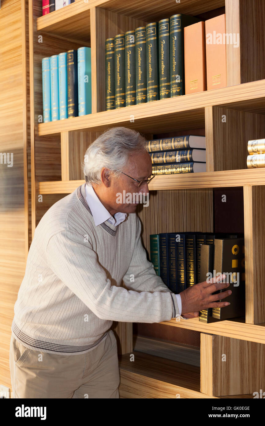 Old man reading a book in the library Stock Photo - Alamy