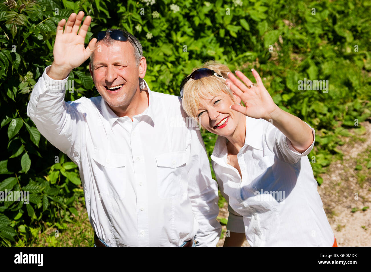 happy elderly couple waving Stock Photo - Alamy