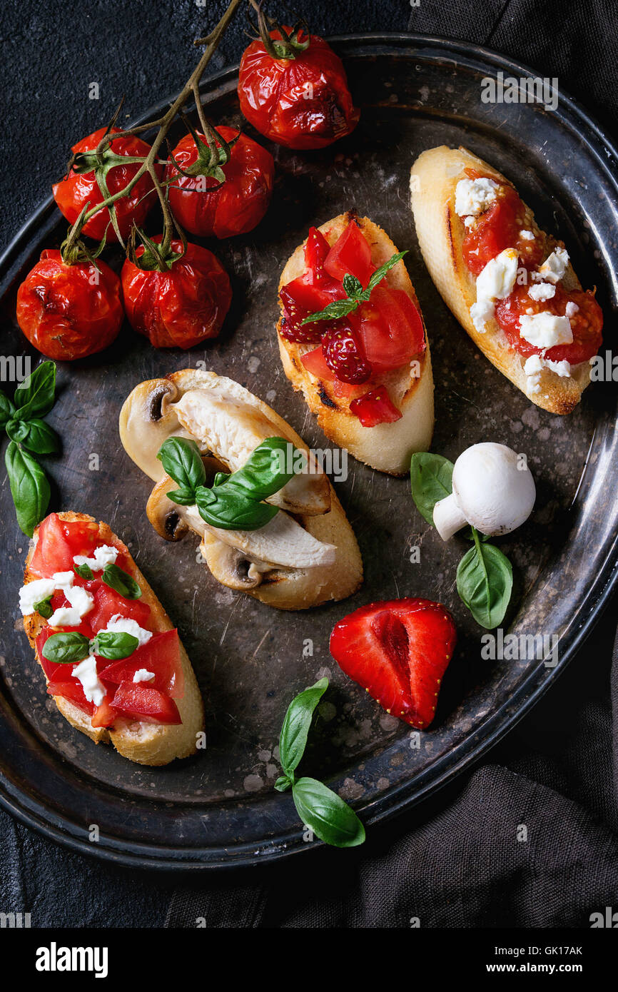 Various of mini bruschetta with tomatoes, strawberries, feta cheese ...