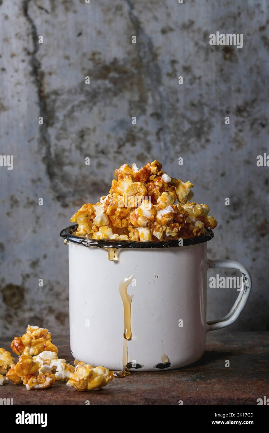 Caramelized sweet popcorn served in vintage enameled white mug with ...