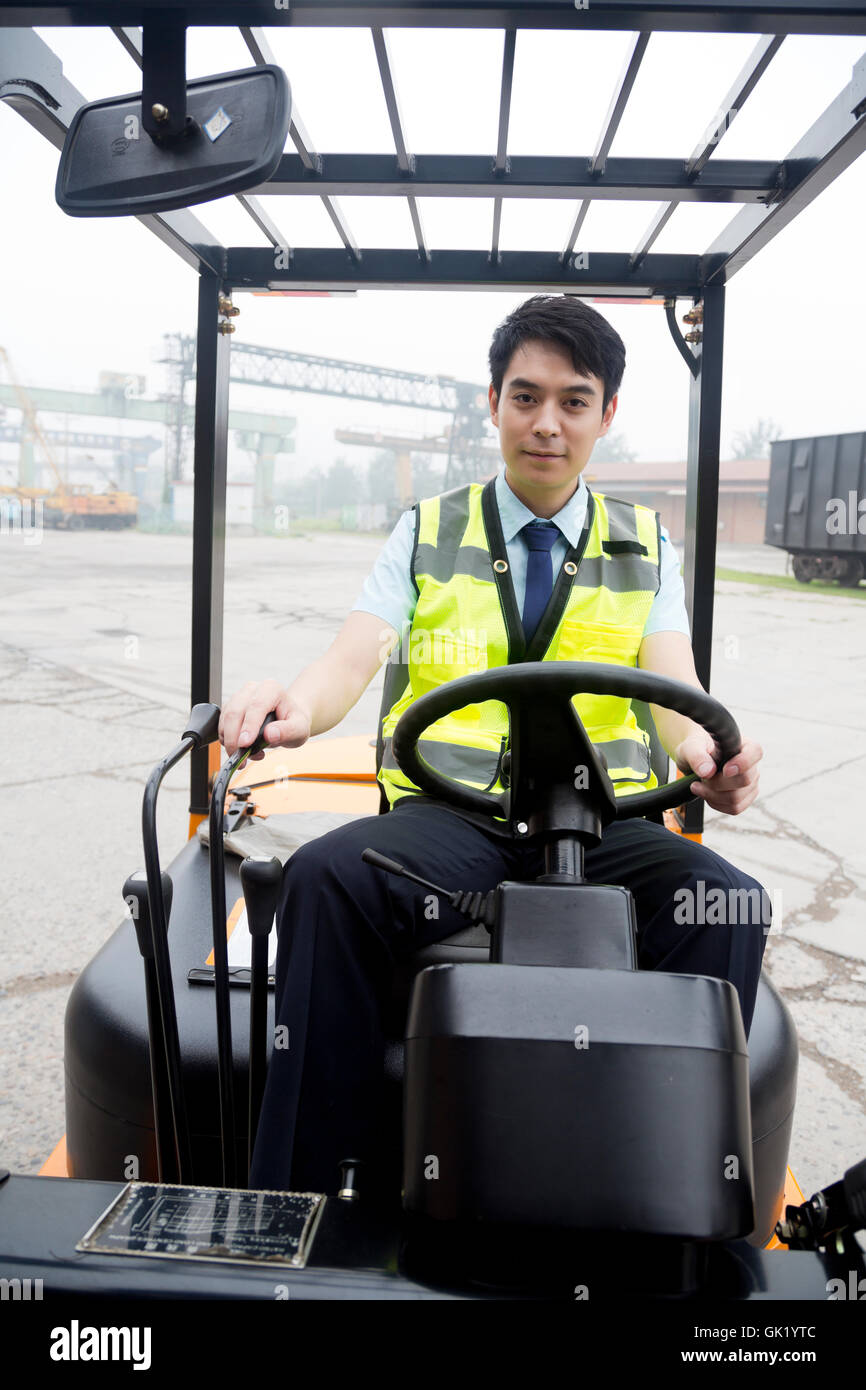 Warehouse worker driving forklift Stock Photo - Alamy