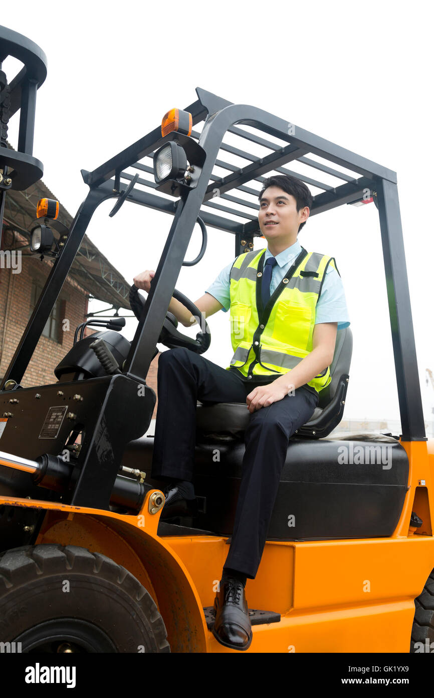Warehouse worker driving forklift Stock Photo - Alamy