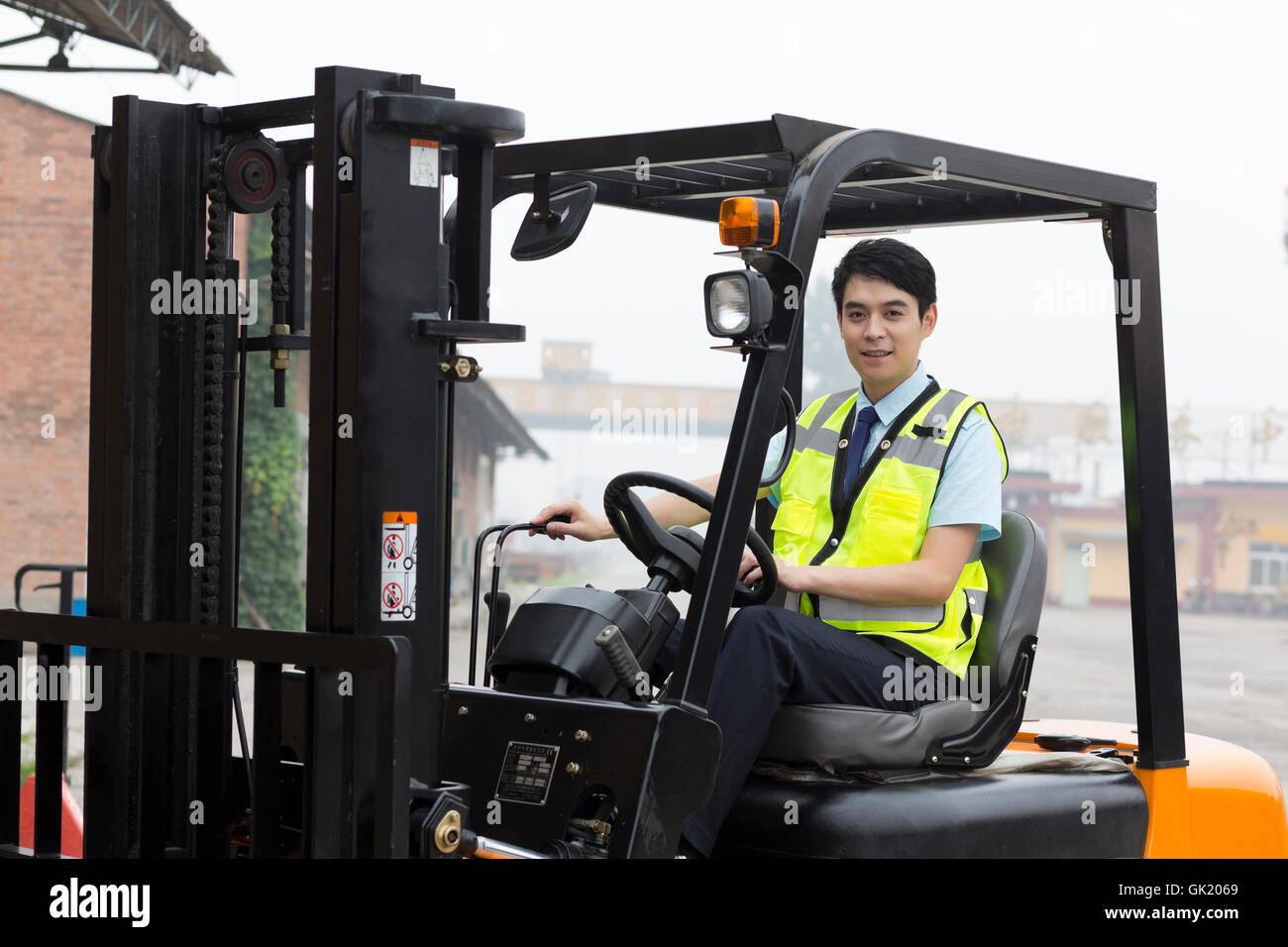 Warehouse worker driving forklift Stock Photo - Alamy