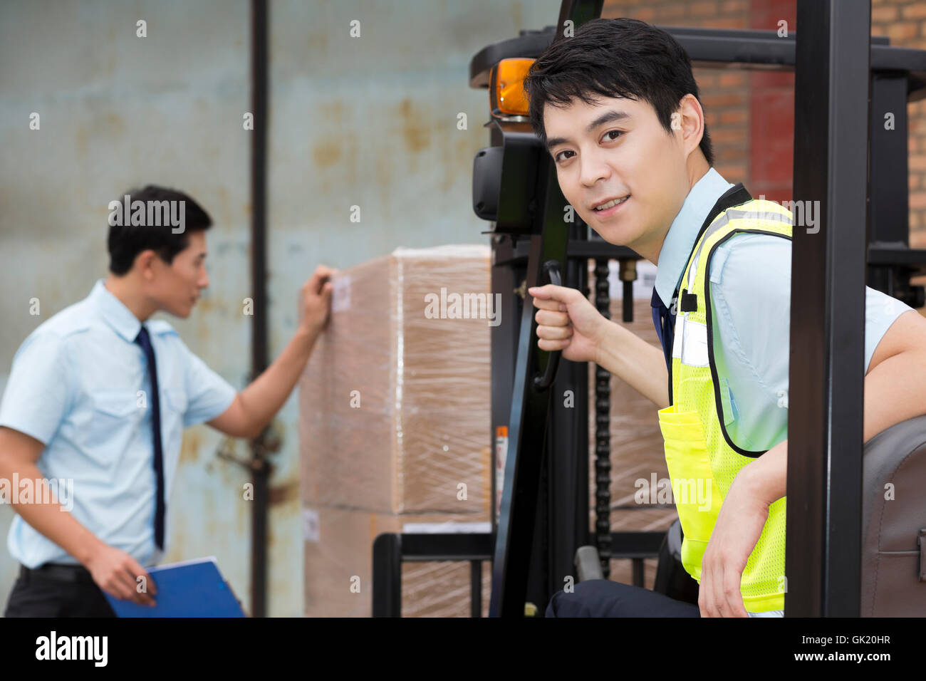 Warehouse worker driving forklift Stock Photo - Alamy