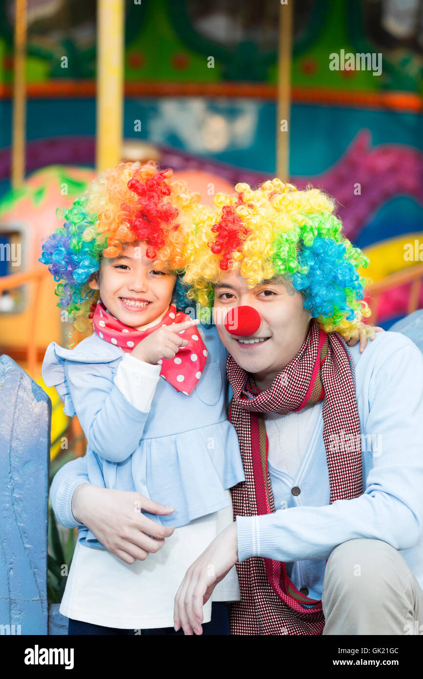 Happy father and daughter playing clowns at an amusement park Stock ...