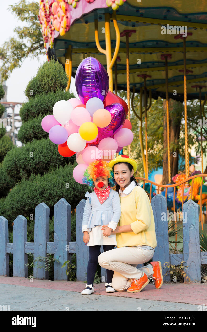 Young mother and daughter dressed as a clown at amusement park Stock ...