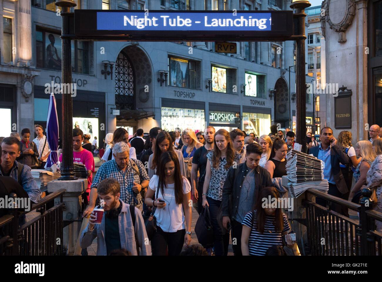 Passengers pass an advert for the night tube at an entrance to Oxford ...