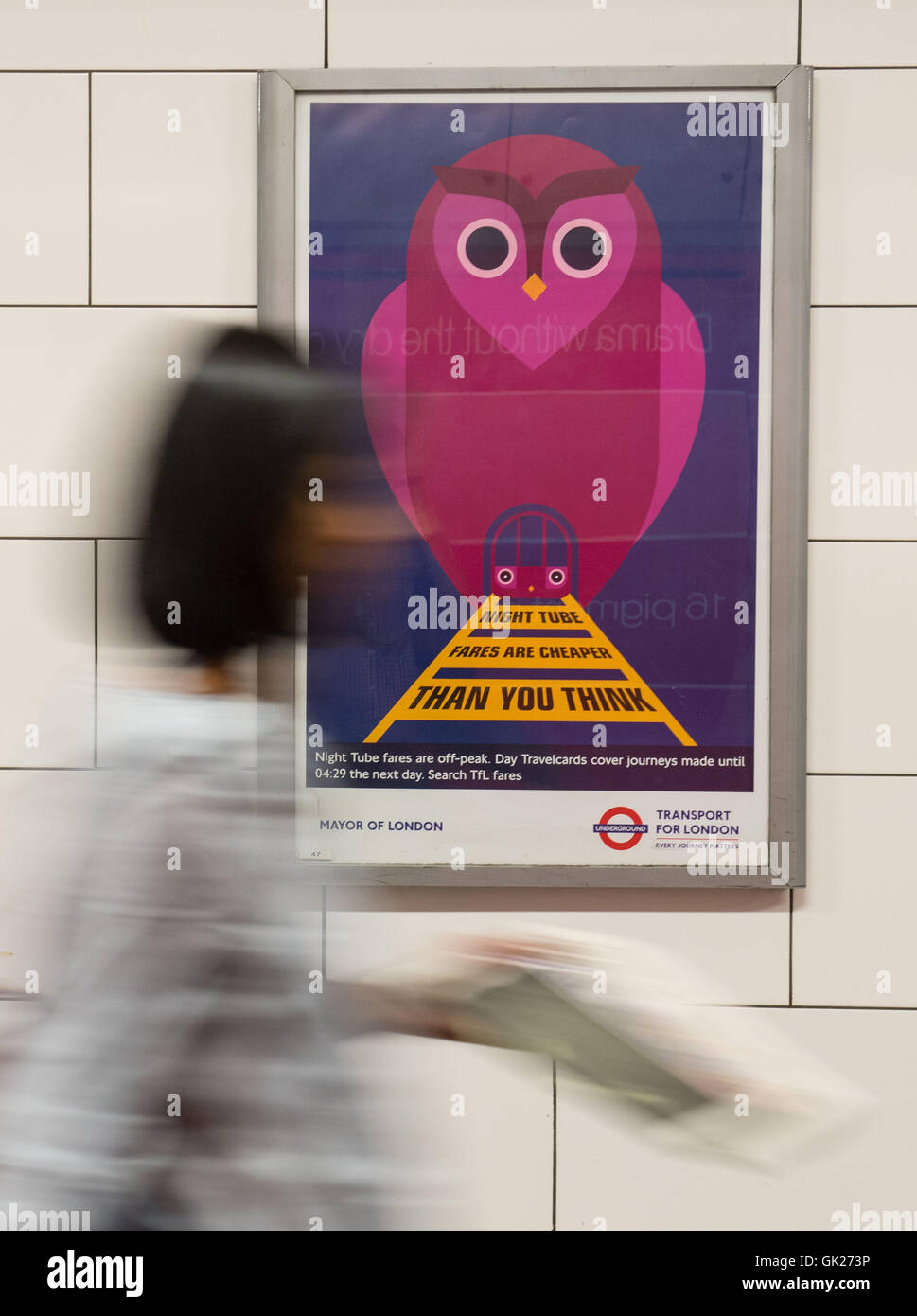A woman passes a night tube advert in Oxford Circus underground station ...