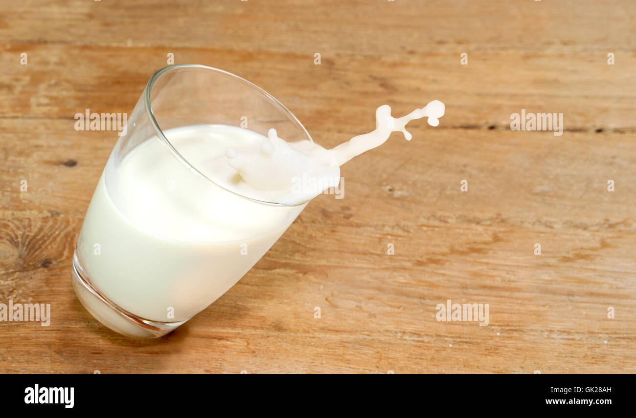 Glass of milk are falling move downward on a wooden table Stock Photo ...