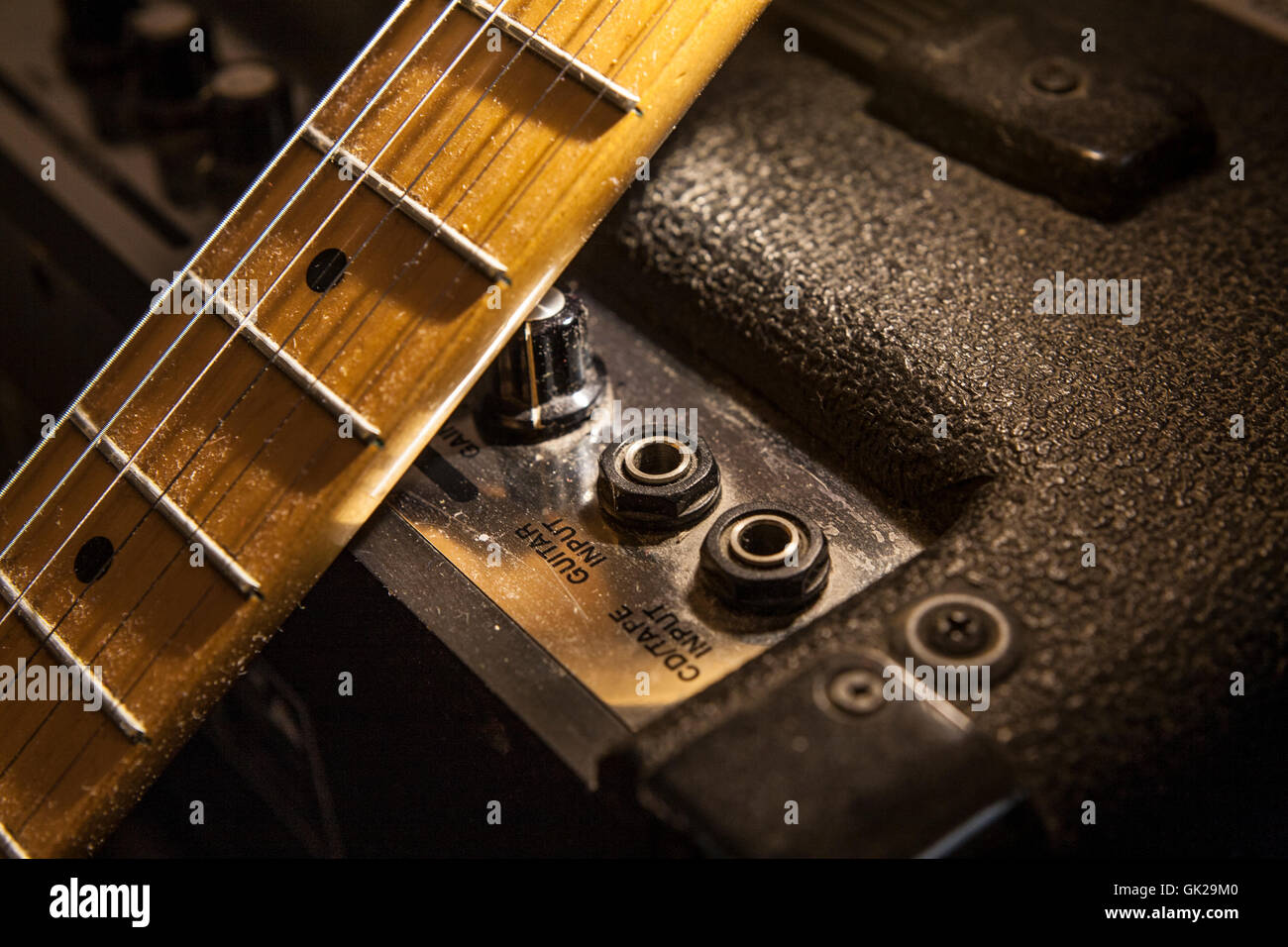 Electric guitar neck over amplifier device. Closeup Stock Photo - Alamy