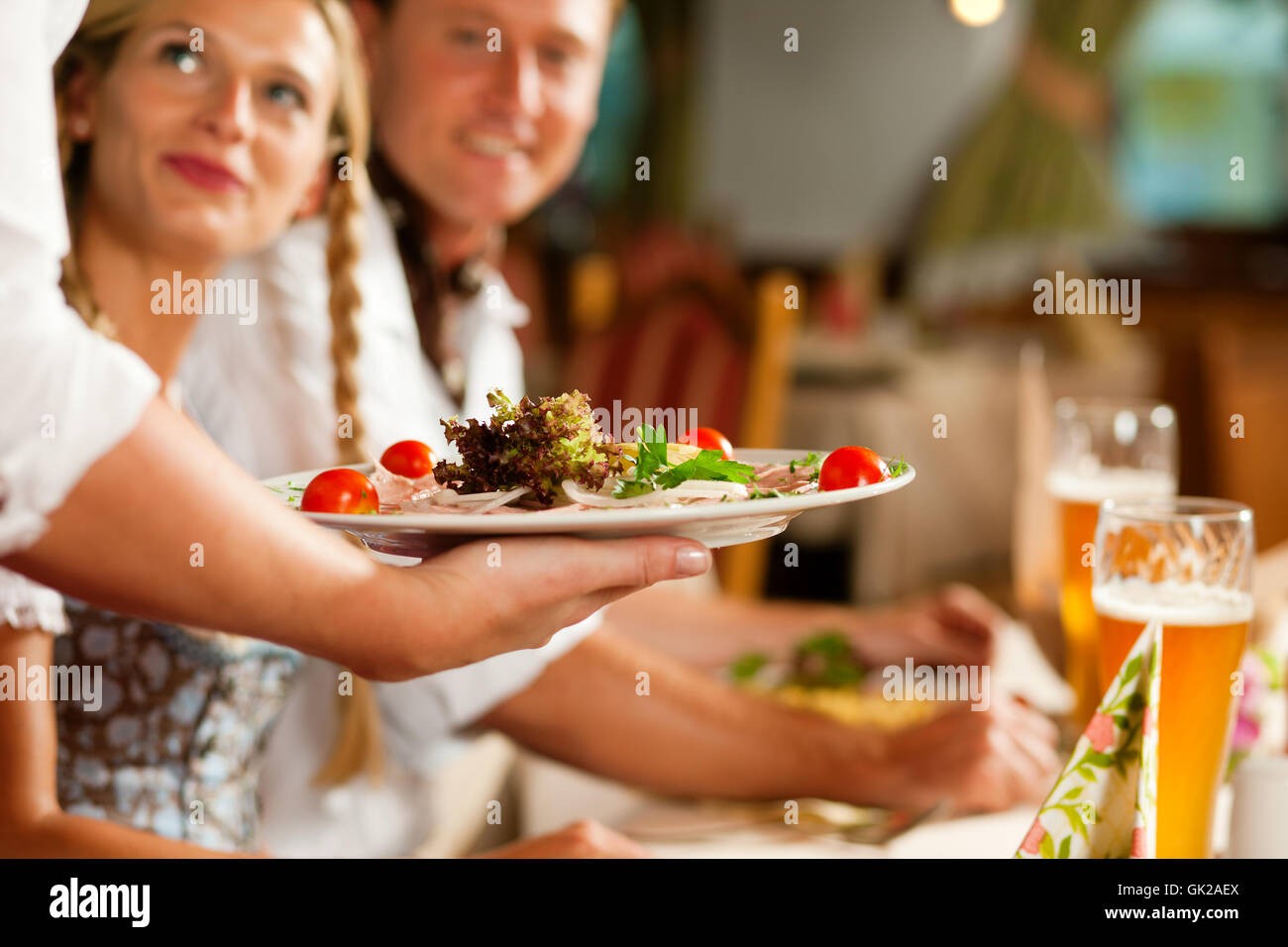 waitress serving in bavarian pub Stock Photo - Alamy