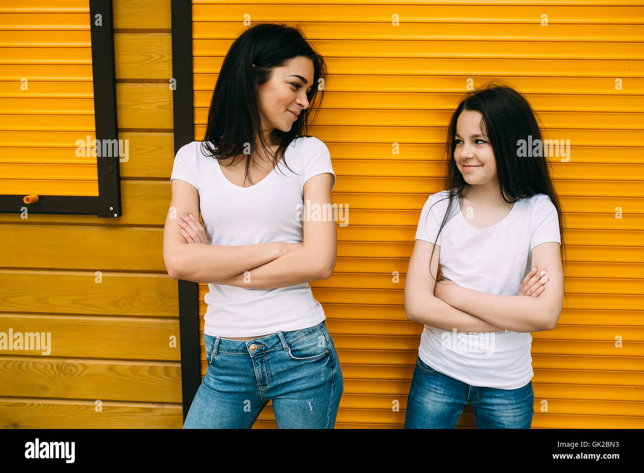 mother and her cute daughter, against wall Stock Photo - Alamy