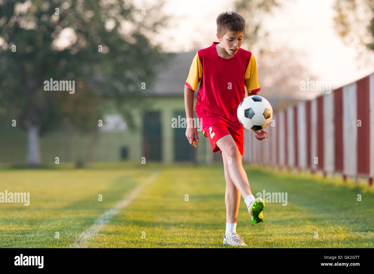 Child playing football on a soccer field Stock Photo - Alamy