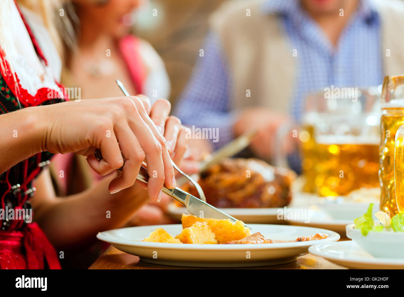 people eating roast pork in restaurant Stock Photo - Alamy