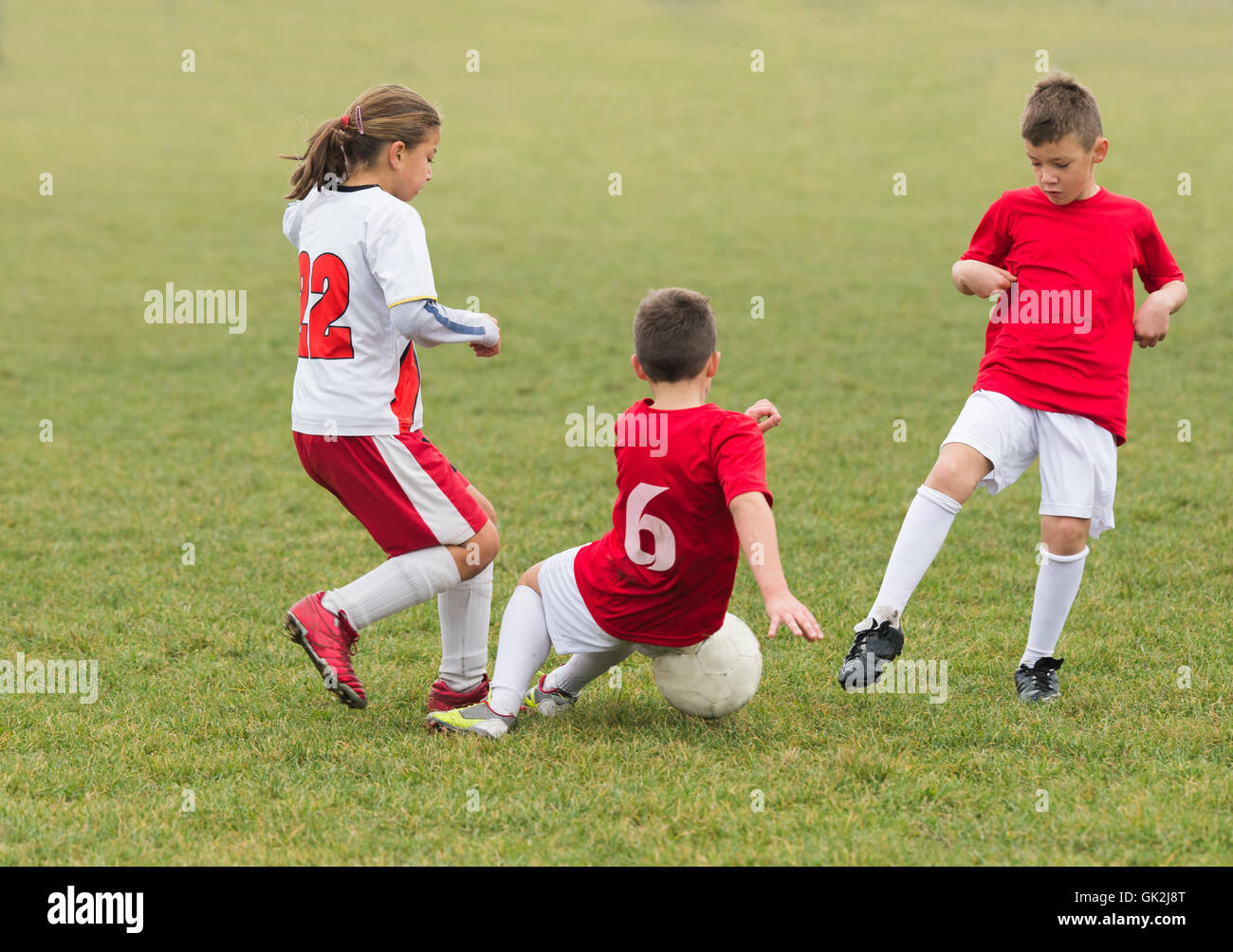 kids kicking football on the sports field Stock Photo - Alamy