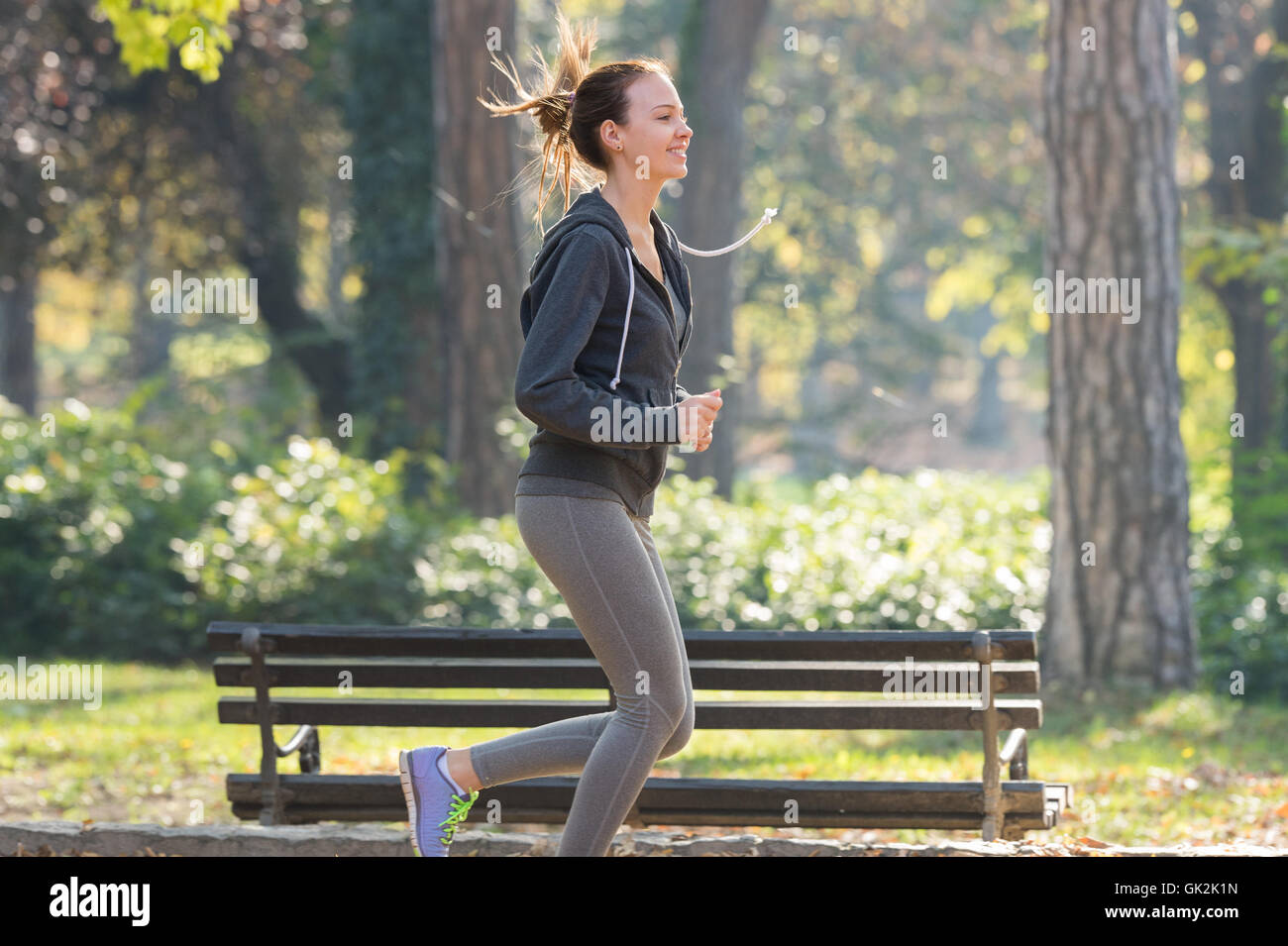 Pretty young girl jogging in the park Stock Photo - Alamy