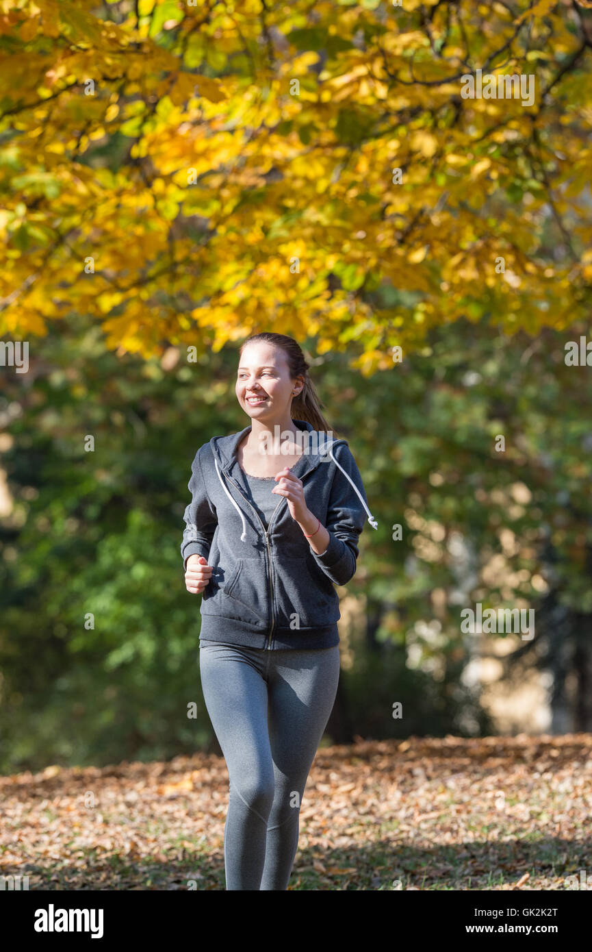 Pretty young girl jogging in the park Stock Photo - Alamy