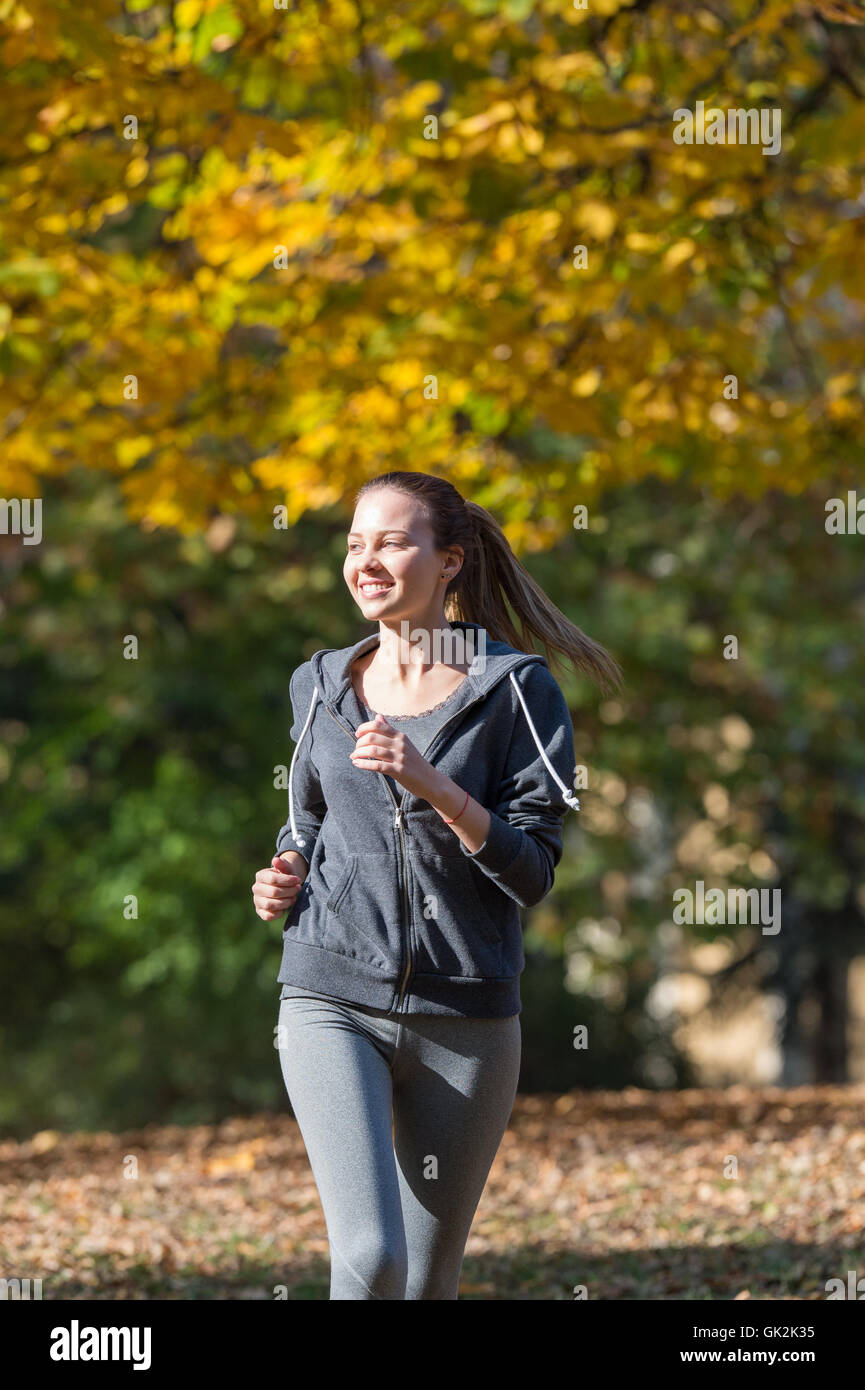 Pretty young girl jogging in the park Stock Photo - Alamy