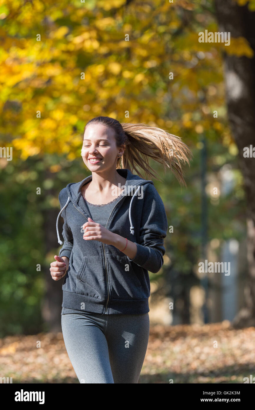 Pretty young girl jogging in the park Stock Photo - Alamy