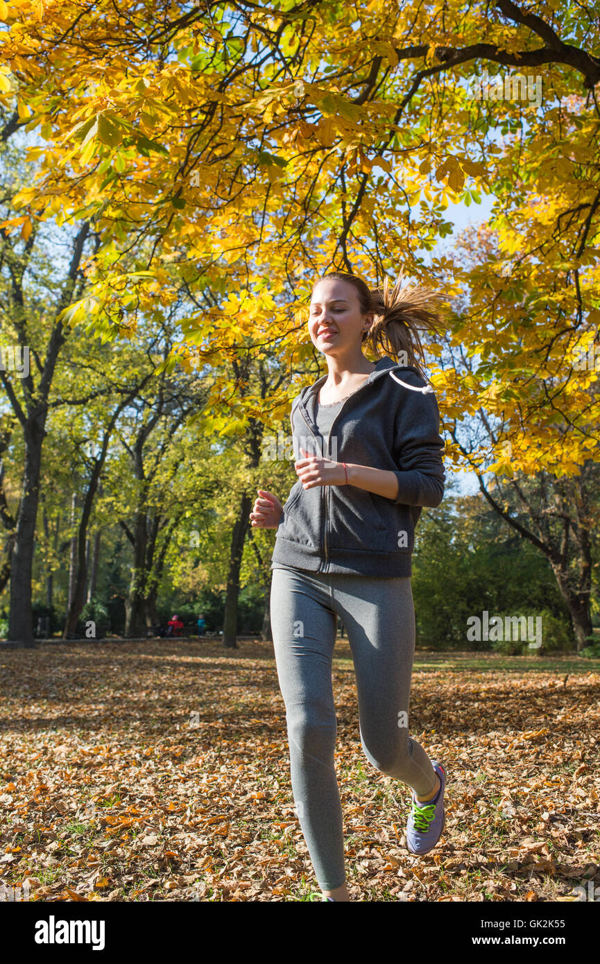 Pretty young girl jogging in the park Stock Photo - Alamy