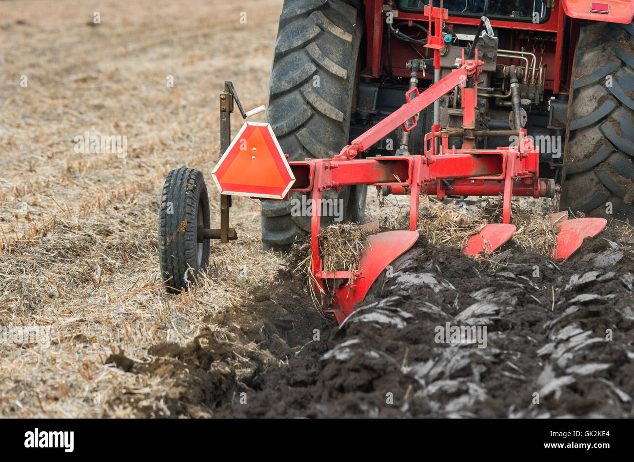 Tractor plowing field at sunset Stock Photo - Alamy