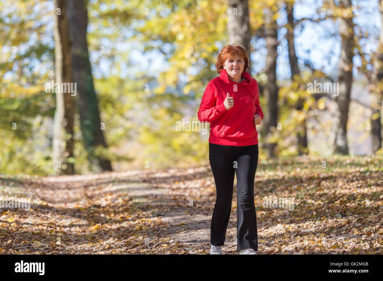 Woman running in autumn park Stock Photo - Alamy
