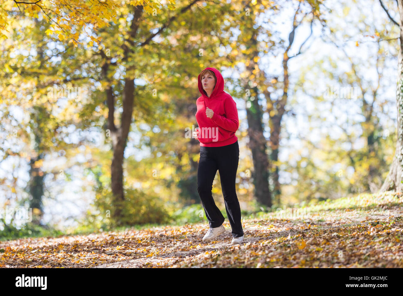 Woman jogging in autumn hi-res stock photography and images - Alamy