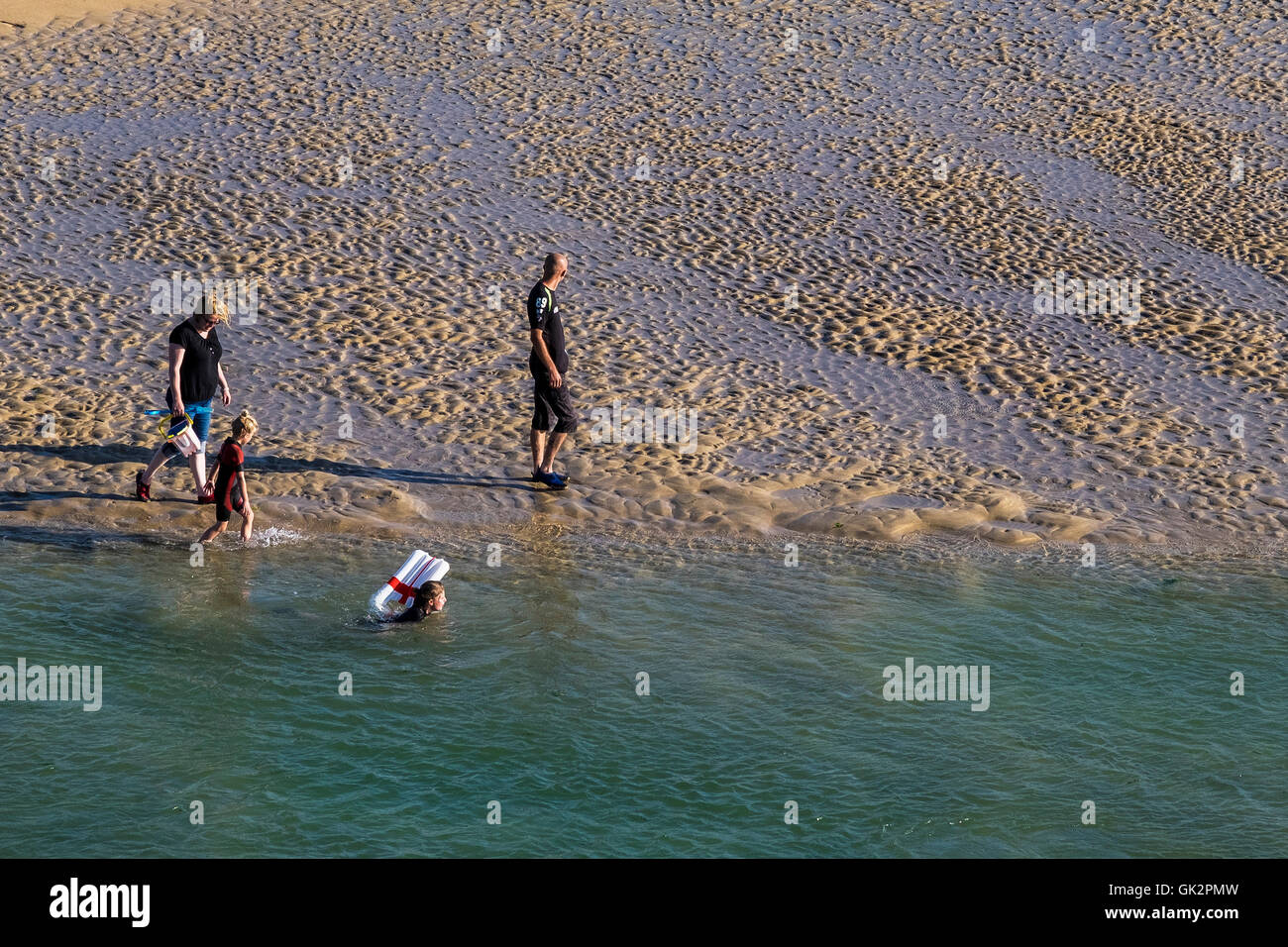 Holidaymakers enjoy a late evening stroll along the Gannel Estuary on ...