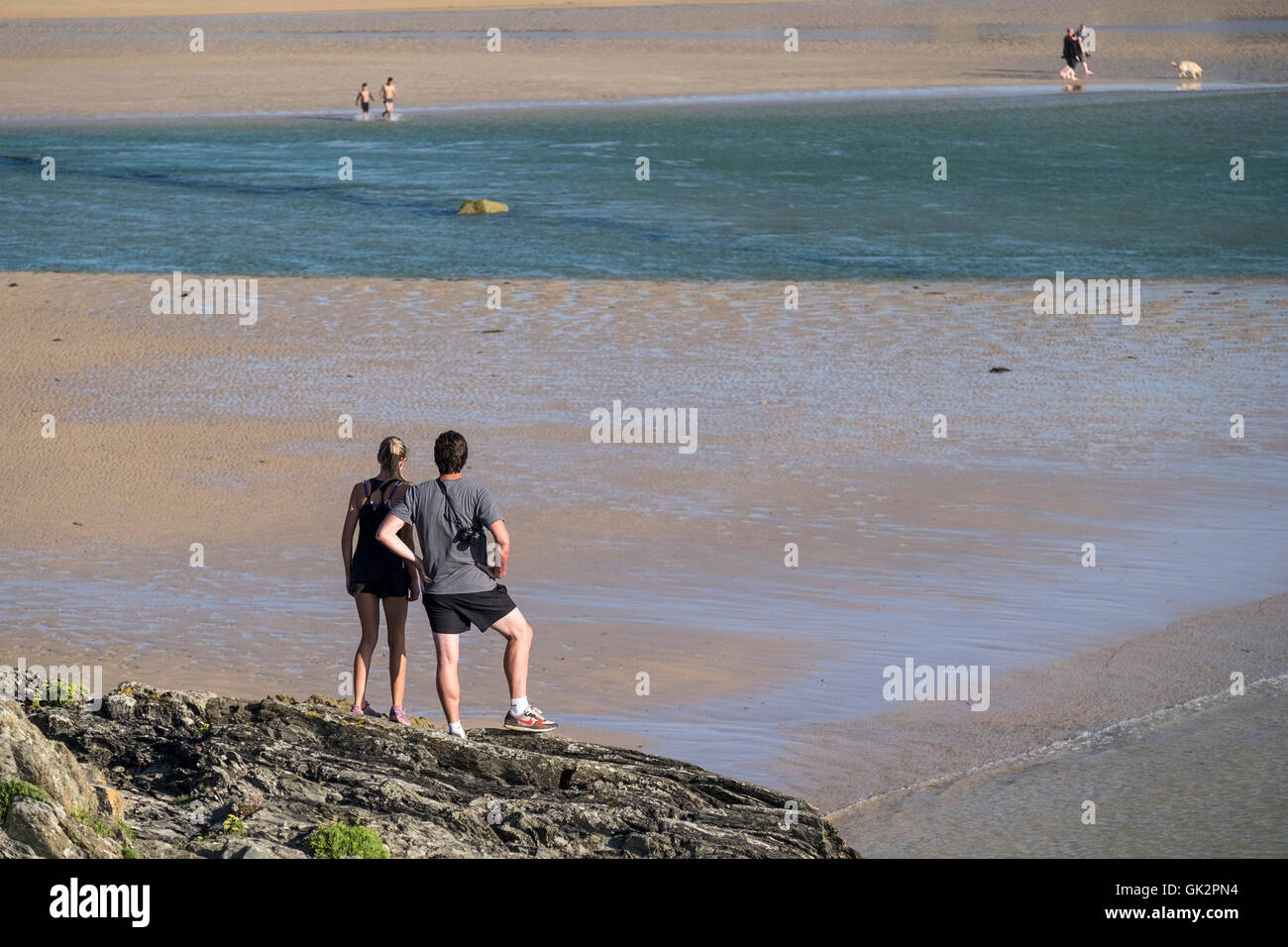 Two people stand on East Pentire and look out over Crantock Beach in ...