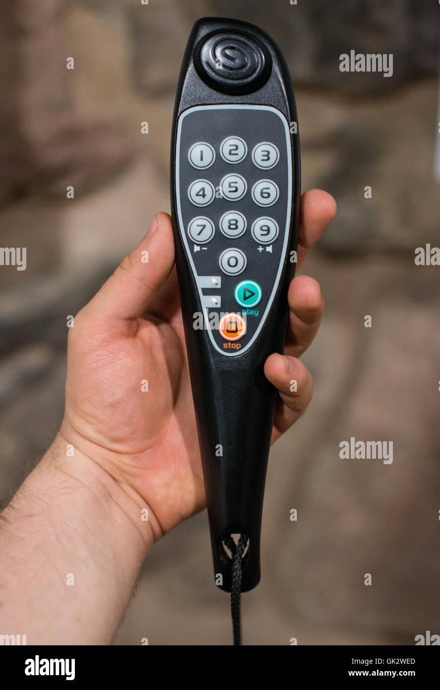 Man holding an audio guide device Stock Photo - Alamy